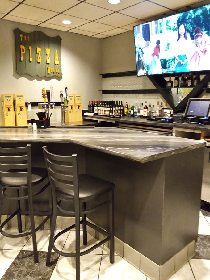 The bar area doesn't just serve drinks—it serves nostalgia, complete with that vintage Pizza House sign watching over proceedings.