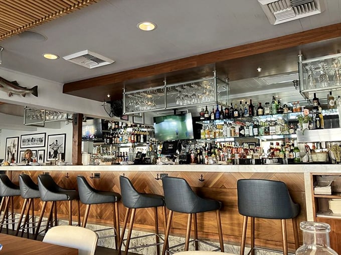 The well-appointed bar invites lingering over craft cocktails and wine. Hanging glassware catches the light like underwater treasures.