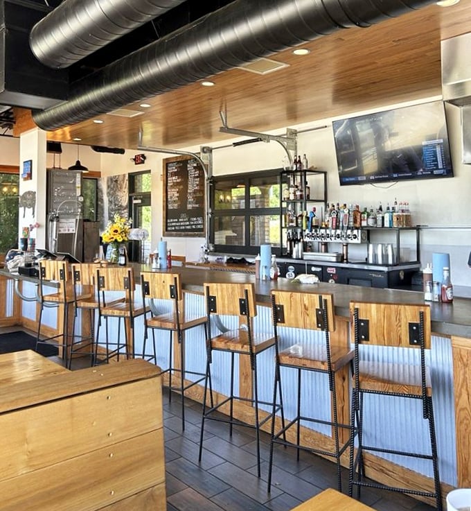 The bar area doesn't just serve drinks—it offers front-row seats to the barbecue theater, complete with industrial-chic lighting and wood-warm ambiance.