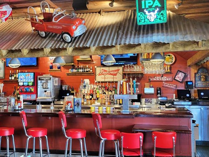 The bar area combines rustic charm with coastal casual—red stools invite you to belly up for a cold one after a day of Anaheim adventures.