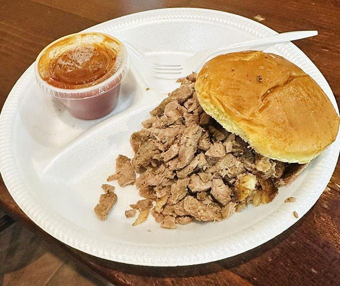 The chopped beef sandwich—where simplicity meets smoke in a handheld masterpiece. That cup of sauce is liquid gold.