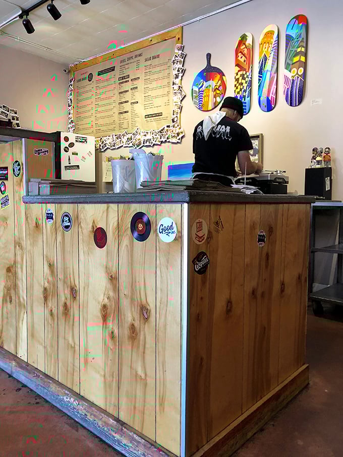 The wooden counter, adorned with stickers and memorabilia, tells stories of sandwich pilgrimages past—each emblem a badge of deli honor.