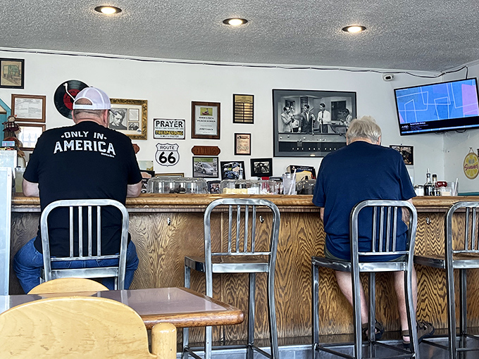 Counter seating where regulars perch like breakfast philosophers, solving world problems over coffee and Route 66 memorabilia.