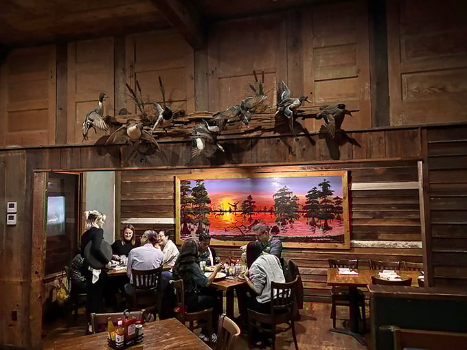 Diners enjoying their meal beneath a stunning bayou sunset painting – because good Louisiana food deserves equally beautiful surroundings.