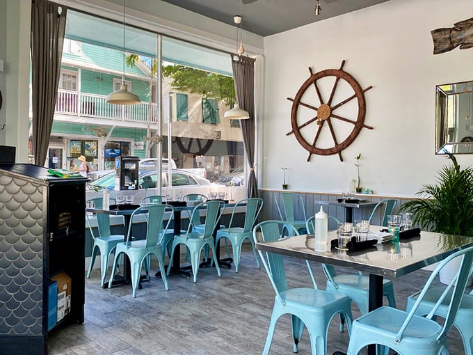 That ship's wheel isn't just decor—it's steering this dining room straight into the heart of Key West's maritime heritage.