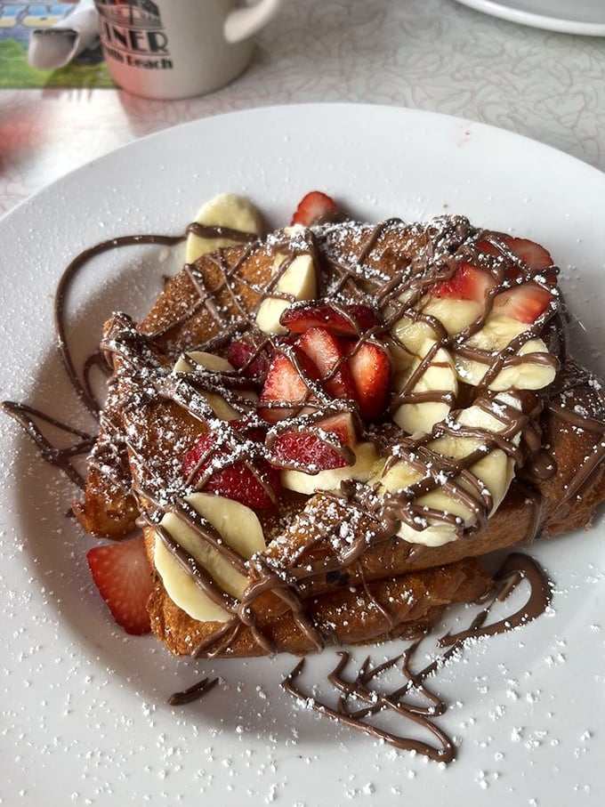 French toast that's dressed for success with strawberries, bananas, and chocolate drizzle – breakfast masquerading as dessert, and nobody's complaining.