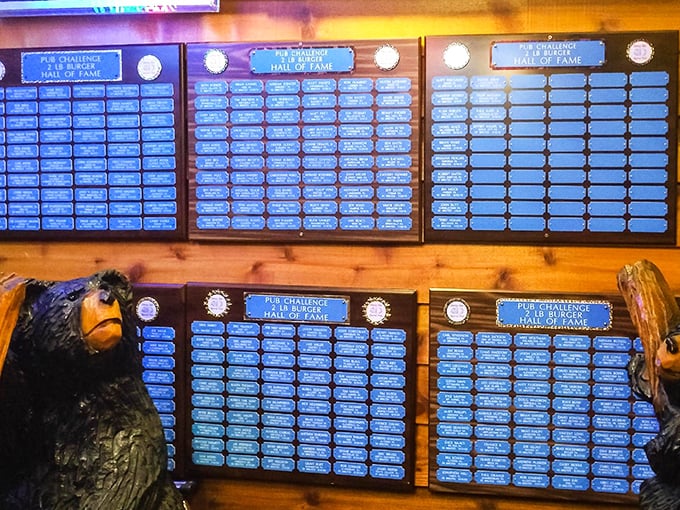 The Hall of Fame wall – where food warriors are immortalized. Each plaque represents someone who looked a monster burger in the eye and didn't blink.