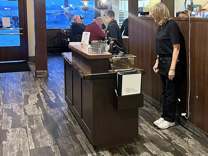 The host station—that magical threshold where hungry strangers enter and satisfied regulars exit, with staff orchestrating the delicious transformation.