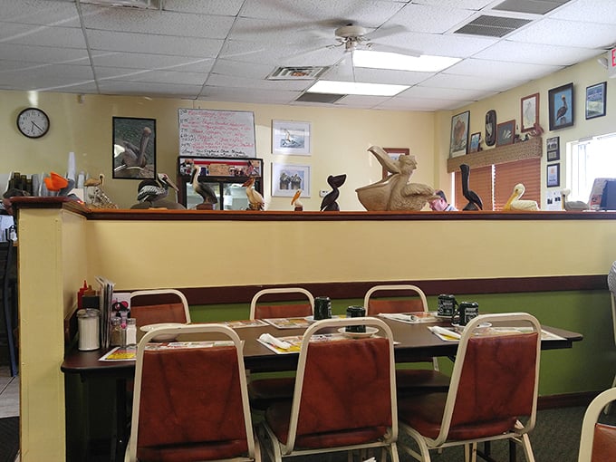 Pelican figurines stand guard along the wall like feathered sentinels, watching over diners while adding whimsical charm to the unpretentious space.
