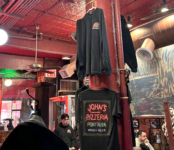 The merch wall says what we're all thinking: "I came for the pizza but also need a souvenir to prove I was here."