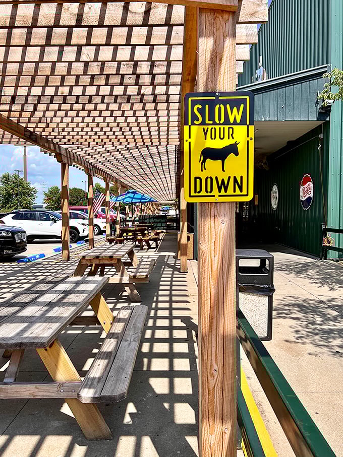 The outdoor waiting area at Lambert's features a "Slow Your Down" sign—advice before entering a restaurant where rolls fly at unexpected moments.