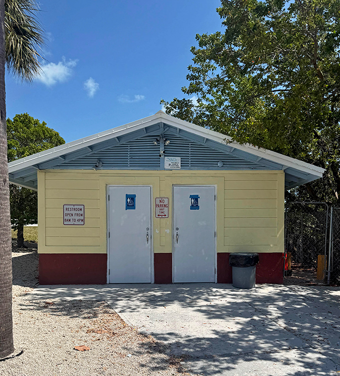 The cheerful restroom building stands as a practical reminder that even paradise needs facilities—thankfully painted in Keys-appropriate colors.