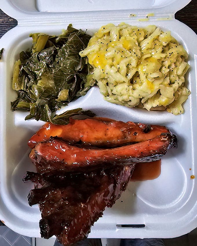 Collard greens, mac and cheese, and barbecued meat—the holy trinity of soul food satisfaction. A styrofoam cathedral of deliciousness.
