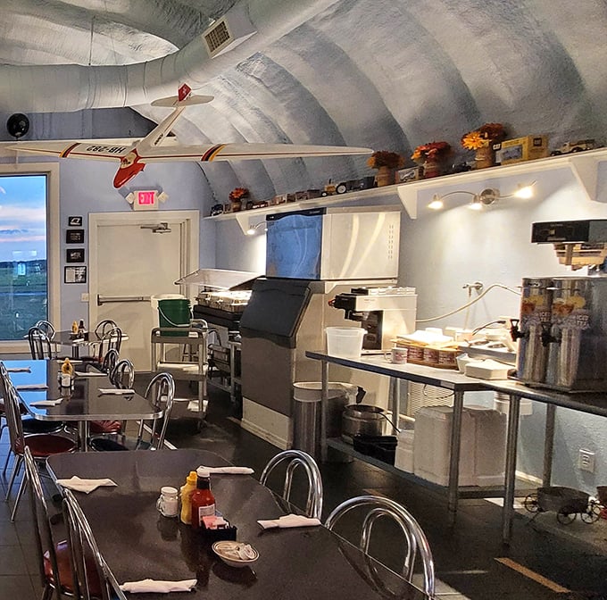 Self-service station beneath a yellow biplane—because coffee tastes better when poured under the watchful eye of vintage aircraft.