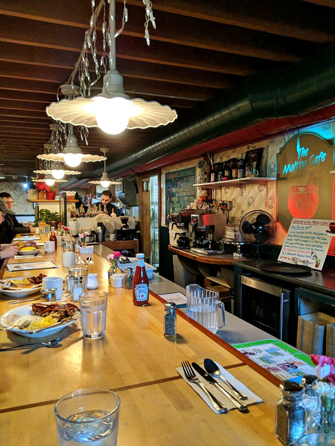 The order counter with its vintage-style wallpaper and hanging lights where breakfast dreams become reality and patience gets deliciously rewarded every time.