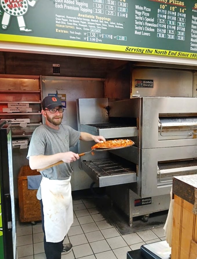 The pizza paddle dance—a skilled artisan at work. There's something hypnotic about watching someone who knows exactly what they're doing.