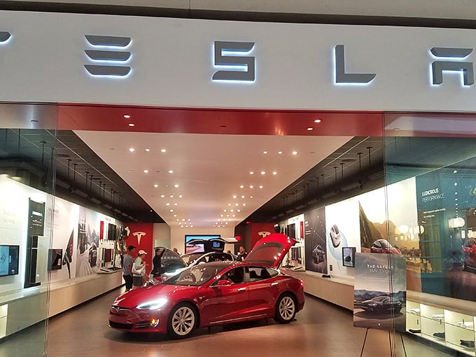 Tesla's showroom gleams with automotive desire—where window shopping takes on new meaning as you pretend you're just "gathering information" about that Model S.