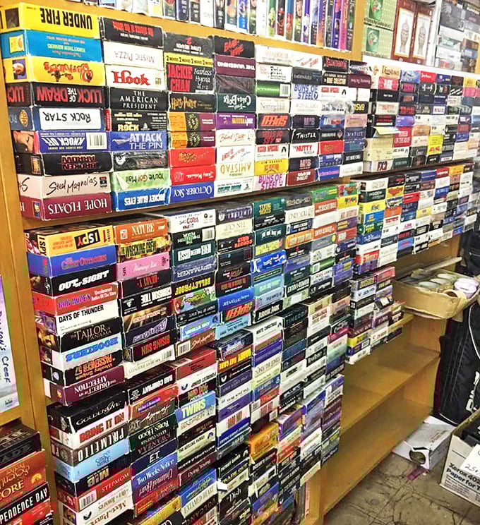 VHS tapes stacked like a physical Netflix from another era—each spine a portal to movie nights before streaming, when "be kind, rewind" was our mantra.