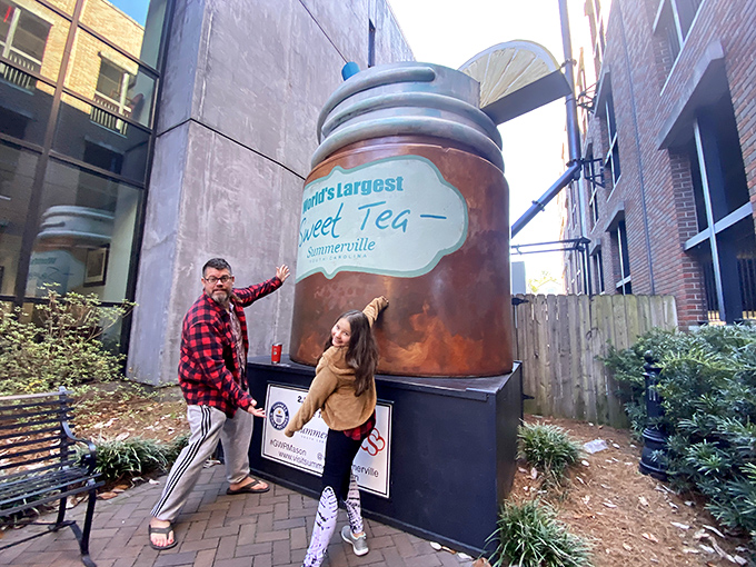 Visitors strike their best "I found the giant tea!" pose. This is what social media was invented for—documenting delightful absurdity. 