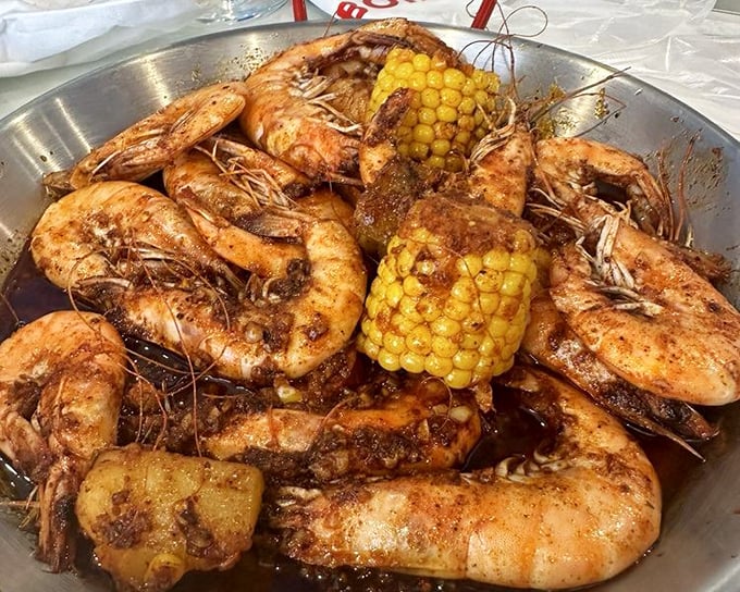 Head-on shrimp swimming in seasoned butter sauce. These aren't just shrimp—they're an event requiring both hands and zero inhibitions.