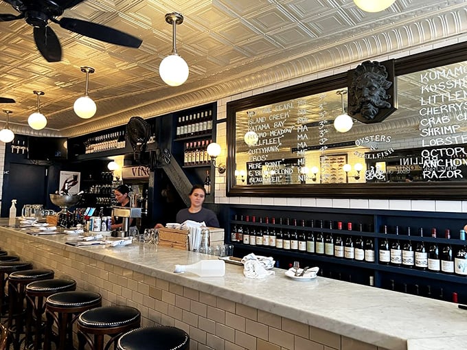 The marble bar where magic happens—watching oysters get shucked while sipping wine is basically dinner theater for food lovers everywhere.