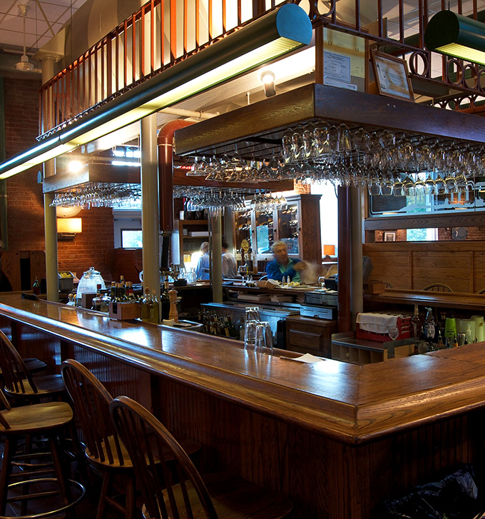 The bar gleams with promise under suspended glassware, offering liquid companionship for your culinary journey through Pennsylvania's industrial past.