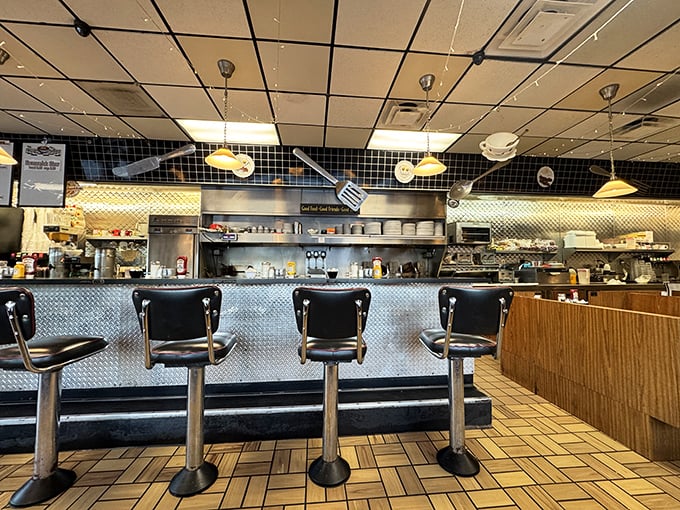 The diner's heart—where coffee flows, orders fly, and conversations bloom. Notice the flowers adding a touch of homey warmth to the stainless steel efficiency.