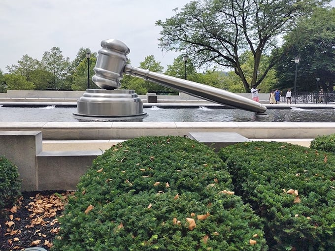 Peeking above the manicured shrubs, the gavel seems to play a game of hide-and-seek with visitors—though at this size, it's not exactly hiding well.