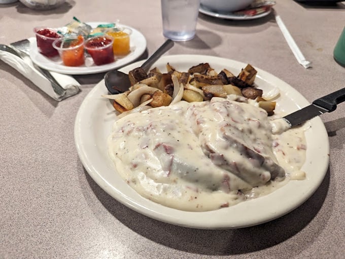 Biscuits and gravy that would make any Southern grandmother nod in approval – a creamy, peppery blanket of comfort atop pillowy baked perfection.