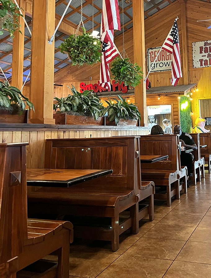 Church pew-style booths under American flags – dining with patriotic purpose. The wooden interior whispers, "Stay awhile, y'all."