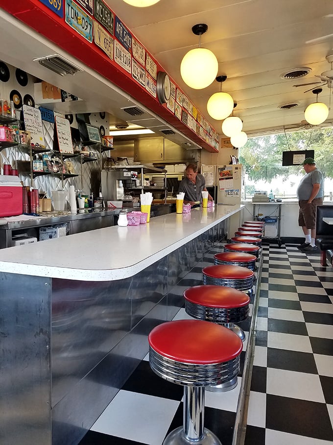 The counter where magic happens – red stools lined up like patient sentinels waiting for the next hungry traveler.