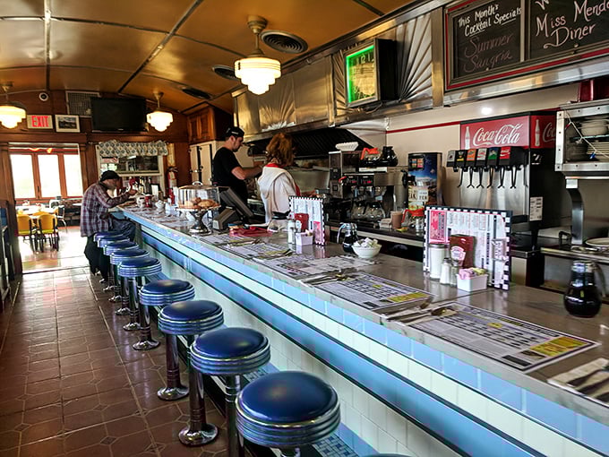 The diner counter – where breakfast magic happens before your eyes. Blue stools invite you to watch the short-order ballet unfold.