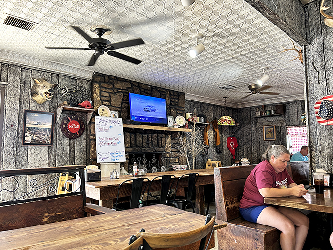 The dining counter offers front-row seats to Granny's rustic charm – stone fireplace, vintage Coca-Cola signs, and ceiling fans that lazily stir memories of simpler times. 