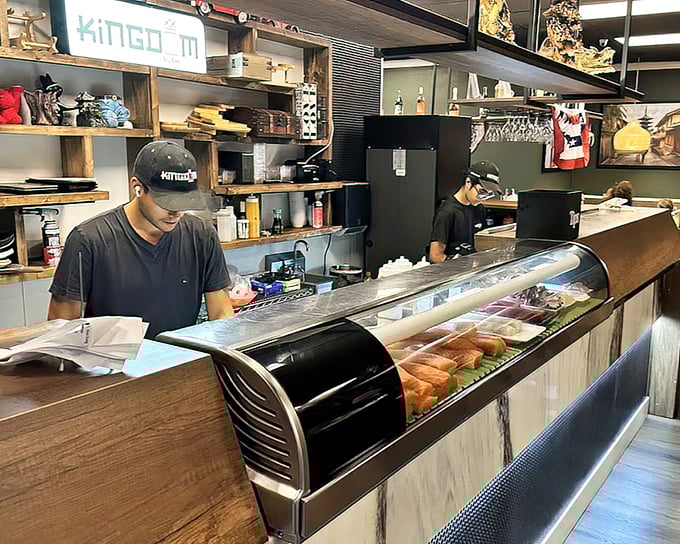 Behind the counter, fresh fish awaits transformation – like watching backstage at a delicious Broadway production.