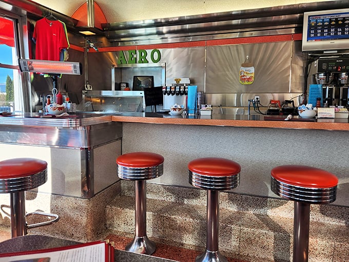 Counter seats: front-row tickets to the greatest show on earth—breakfast being made. The red vinyl stools have witnessed countless life stories.