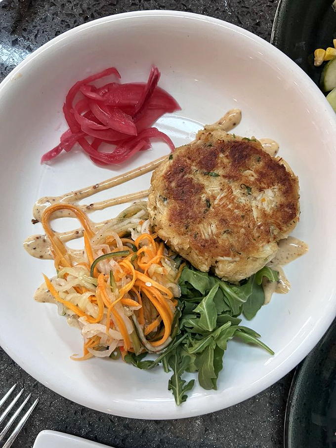 This crab cake isn't playing around—all crab, no filler, with pickled vegetables that cut through richness like a well-timed joke.