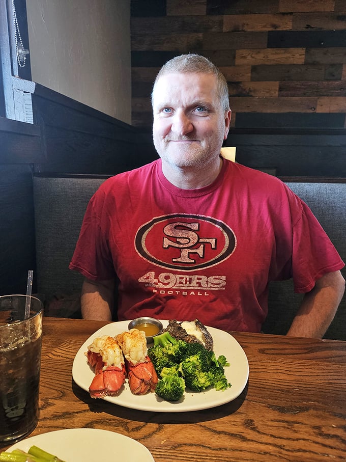 A satisfied diner grins before his surf-and-turf plate—the universal expression of "I made the right decision tonight" captured in real time.