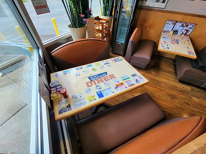 A booth by the window – prime real estate in the diner kingdom. That laminated placemat has seen more breakfasts than most people have had hot dinners.