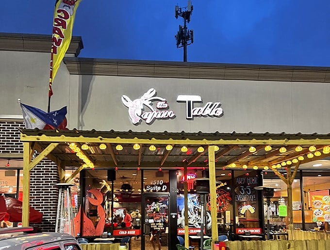 The Cajun Table's storefront glows with warm invitation, its crawfish logo promising authentic flavors that locals line up for nightly.