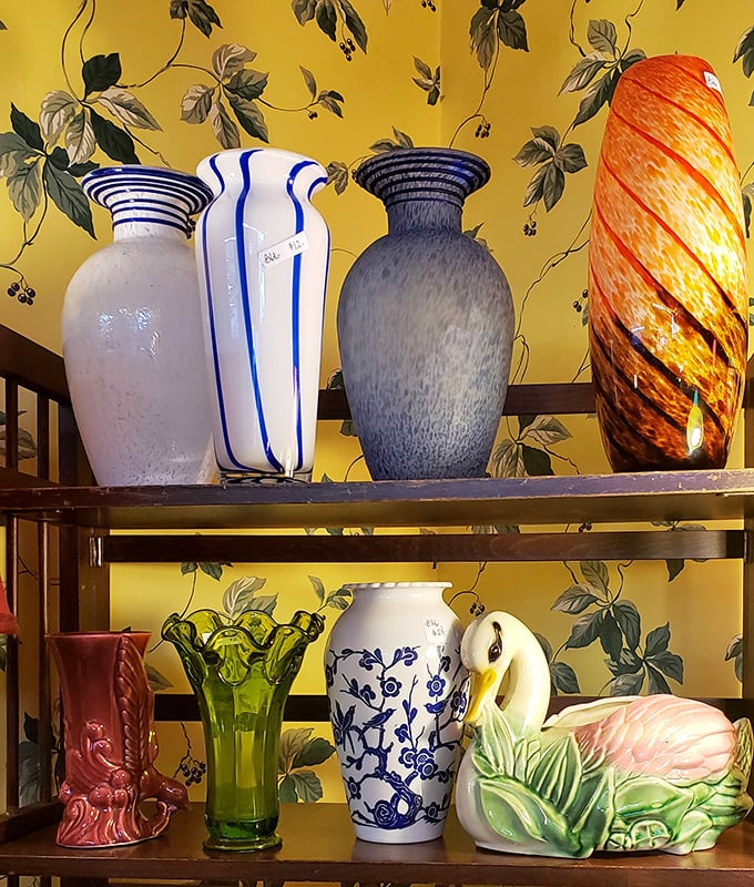 Vases that outlived their original owners, now waiting for new homes. That striking orange swirl piece would make even grocery store flowers look museum-worthy.