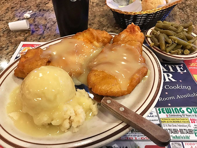 Comfort food nirvana: tender chicken smothered in gravy alongside creamy mashed potatoes and green beans—a plate Norman Rockwell would paint.