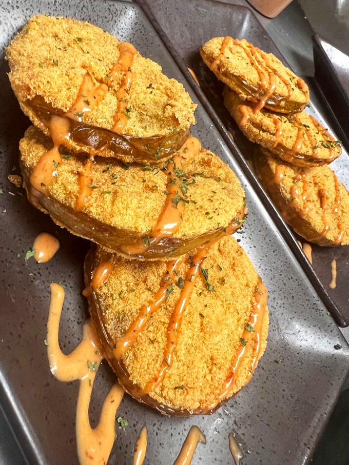 Fried green tomatoes drizzled with remoulade—Southern ingenuity on a plate that transforms the humble tomato into something magical.