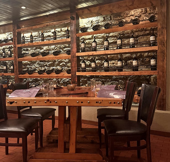 The wine wall transforms dinner into a choose-your-own-adventure of vintages, with bottles nestled against stone like treasures in a very delicious cave.