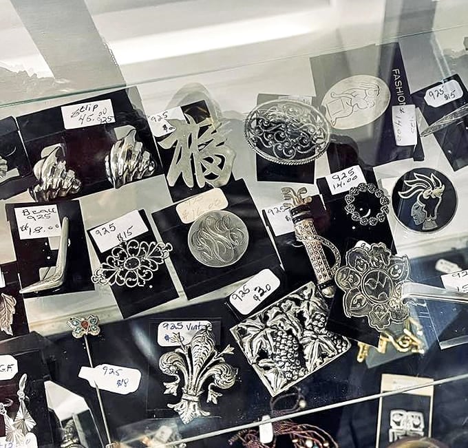 Behind glass, vintage brooches and pins await their next chapter. These tiny metal masterpieces once adorned someone's Sunday best or graduation gown.
