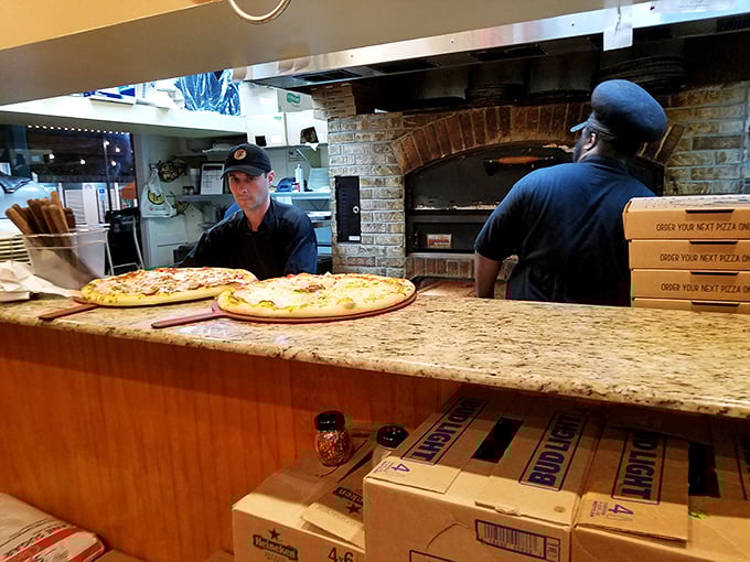 Behind the counter, pizza artisans work their magic at the brick oven—the heart of Flippers' operation and source of countless happy food memories.