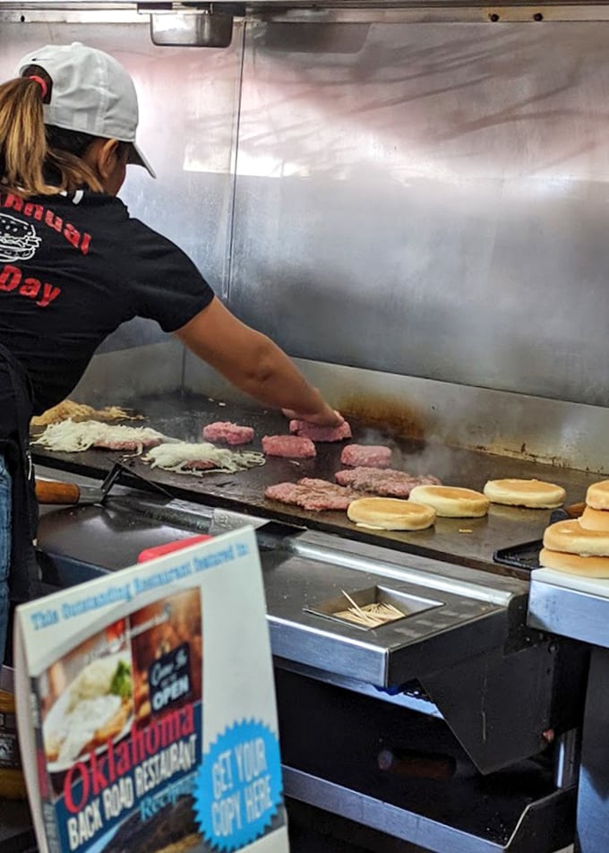 Burger alchemy happens here—where skilled hands press onions into patties on a seasoned grill that's seen more action than an action movie.