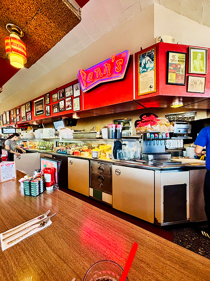 Behind the counter, where magic happens—the neon Pann's sign glowing like a beacon of hope for the hungry and caffeine-deprived.