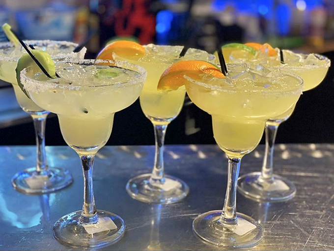 Classic margaritas lined up like beauty contestants—each one wearing a salt crown and citrus jewelry, waiting for your verdict.