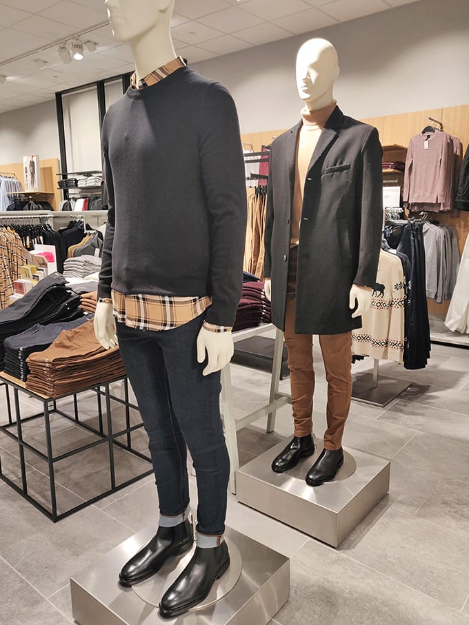 Mannequins modeling the art of layering—that Burberry-inspired plaid peeking out says "I'm worth it" while the outlet price whispers "bargain."