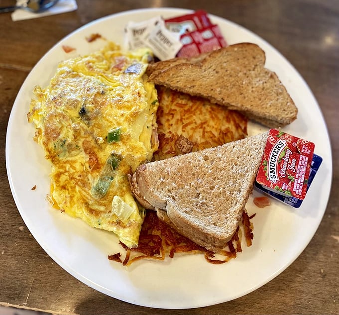 This omelet has more fillings than my last dental appointment, but infinitely more enjoyable. Paired with toast and hash browns for the win.